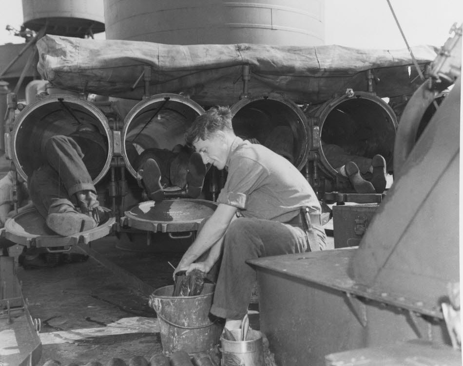 Cleaning torpedo tubes on USS Nicholas (DD-449)