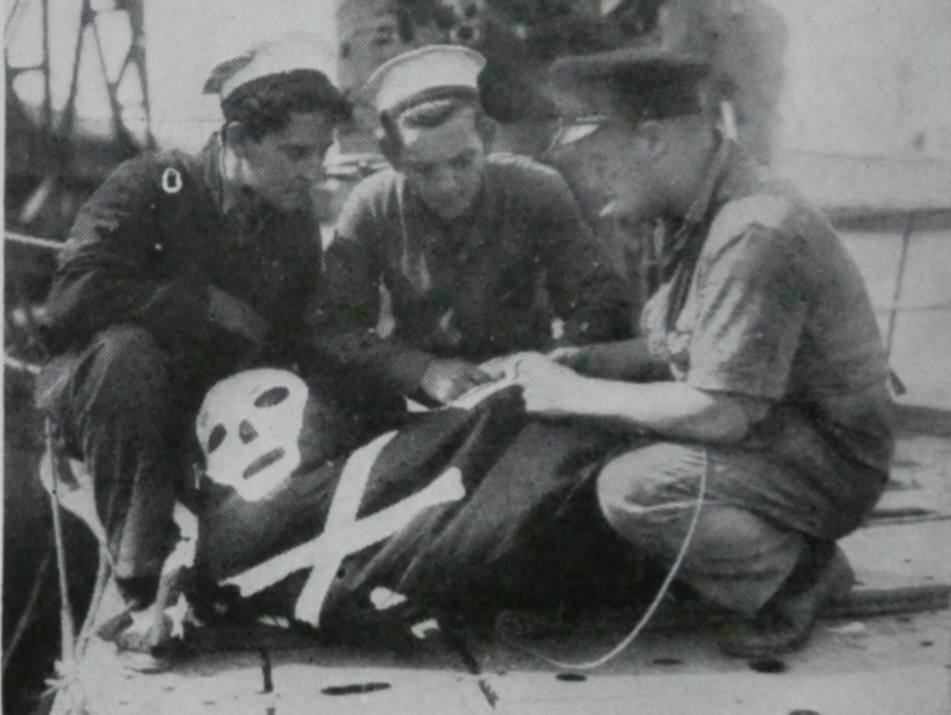 Crew of HMS Unsparing sowing victories onto flag